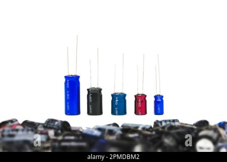 Electrolyte or electrolytic capacitor row isolated on white background with reflection ...