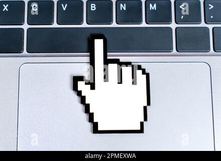 Blocky plastic pixel cursor model clicks enter key on the modern laptop ...