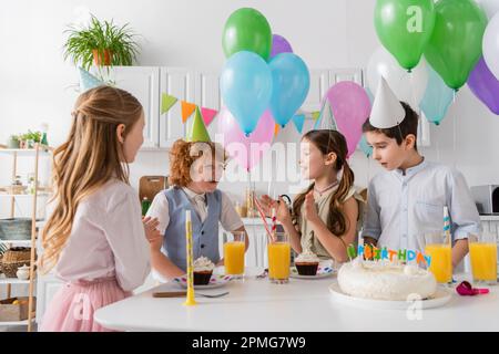 happy kids clapping hands and singing happy birthday song next to cake ...
