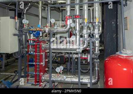 indoor industrial steam boiler with lots of piping, pumps and valves ...