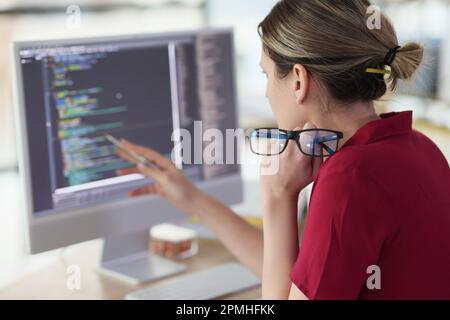 Female programmer checks code looking at screen of computer Stock Photo ...