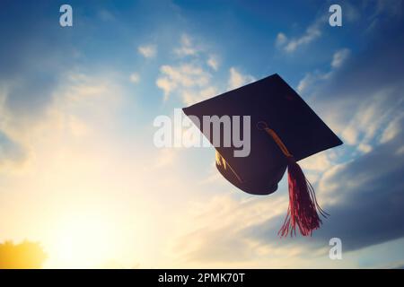 Graduation cap thrown into the blue sky. Graduation from an educational ...