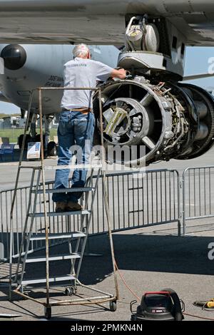 An mechanic rebuilds a vintage military propeller driven aircraft at ...