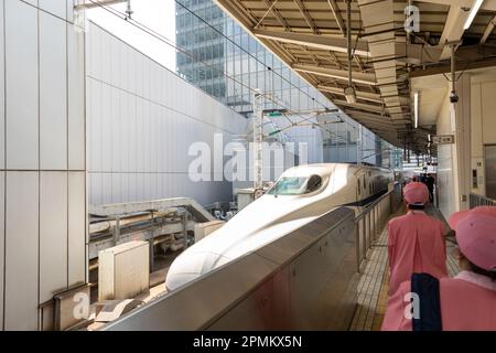 April 2023 Tokyo rail station cleaners wait to board the bullet train ...