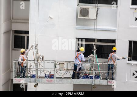 Three painting specialists on elevator scaffold working at height to re ...