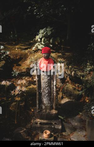 Stone Jizo statues are decorated with red bibs and hats Stock Photo - Alamy