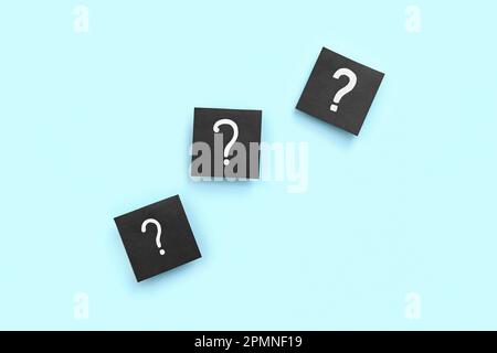 Papers with question marks on blue wooden background Stock Photo - Alamy