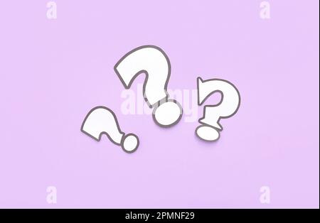 Paper with question marks on lilac background Stock Photo - Alamy