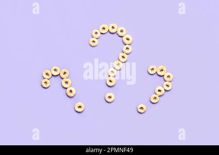 Question marks made of cereal rings on lilac background Stock Photo - Alamy