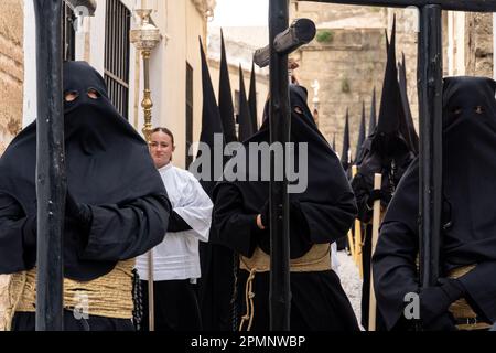 Penitents wearing black hoods carry wooden crosses from the St. Mary ...