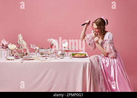 One hungry princess wearing baroque dress holding sandwich and looking ...