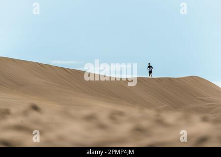 Hiker among sand dunes in the desert Stock Photo - Alamy