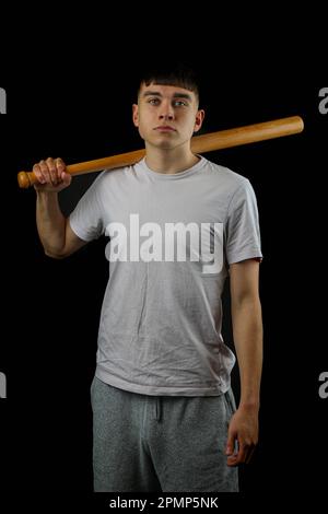A teenage boy with a basball bat against a black background Stock Photo ...