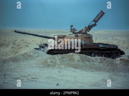 A destroyed Iraqi T-55 main battle tank lies abandoned beside a road at ...