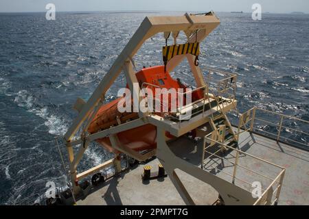Aft of orange free fall lifeboat with door secured on launching ramp ...
