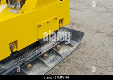 Vibratory plate compacts gravel base layer Stock Photo - Alamy