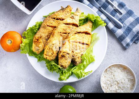 Fried "peroa" fish, lettuce salad, tomato, lemon, rice, beans and ...