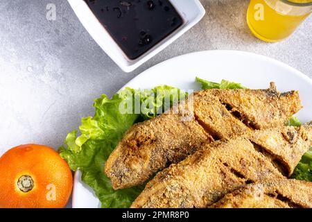 Fried "peroa" fish, lettuce salad, tomato, lemon, rice, beans and ...