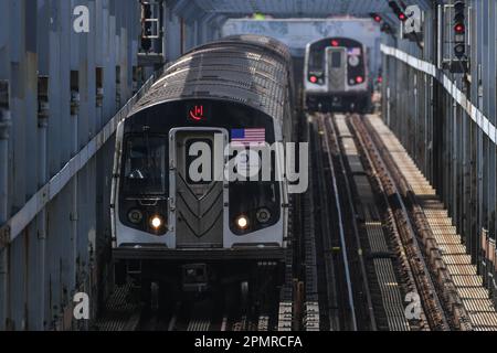 Two subway trains cross over the Williamsburg Bridge on April 14, 2023 in New York City Stock ...