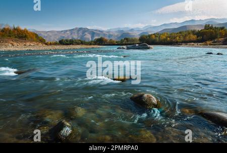 A view of a Kokcha river passing through trees and mountains; Fayzabad ...
