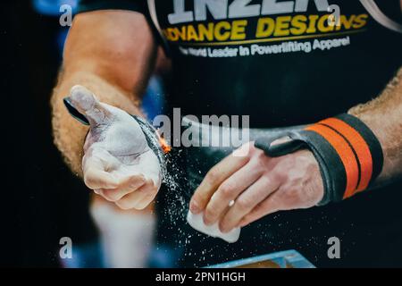 athlete powerlifter apply gym chalk on his hands for bench press ...