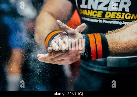 athlete powerlifter apply gym chalk on his hands for bench press ...