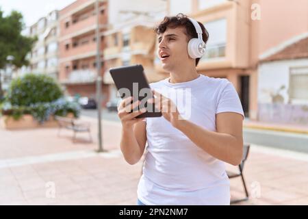 Non binary person using touchpad device at night surprised pointing ...