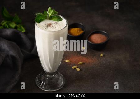 Indian Salty lassi with mint leaves and kala namak on black background ...