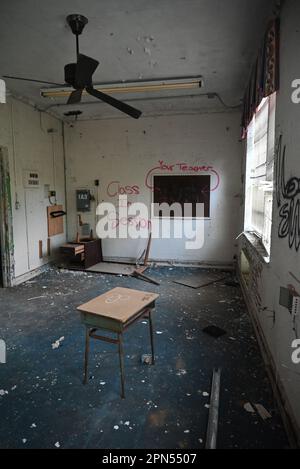 A student desk sits in a debris filled classroom at a school vandalized ...