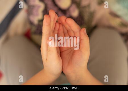 children's outstretched hands on a blurry background close-up asking ...