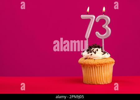 Birthday cake with candle number 73 - Blue background Stock Photo - Alamy