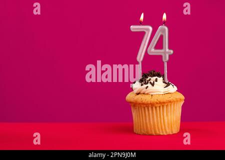 Candle number 74 - Cake birthday in blue background Stock Photo - Alamy