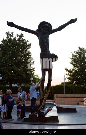 People venerating the statue of the Risen Christ in Medjugorje. The ...