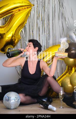 Caucasian woman drinking champagne from bottle celebrating her 40 ...