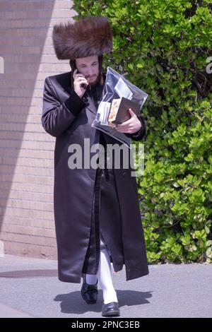 An orthodox Jewish man returns from temple on Purim wearing a shtreimel ...