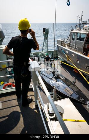 Royal Canadian Navy sailors crane a Meggitt Hammerhead drone into the ...