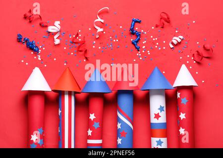 Firework rockets, serpentine and confetti for Independence Day on red ...