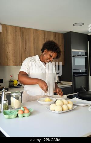 Young cuban woman breading mashed potatoes balls Stock Photo - Alamy