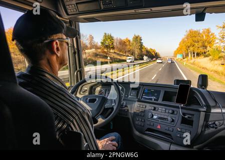 View from inside the cab of the truck. Car transport. The truck is ...