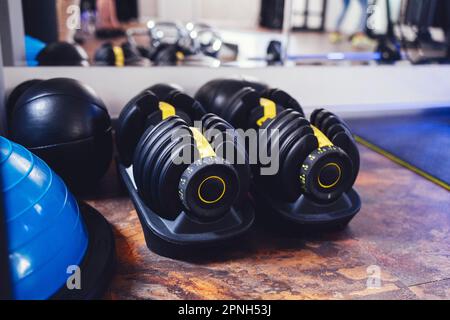 Dumbbells on stand in modern gym Stock Photo - Alamy
