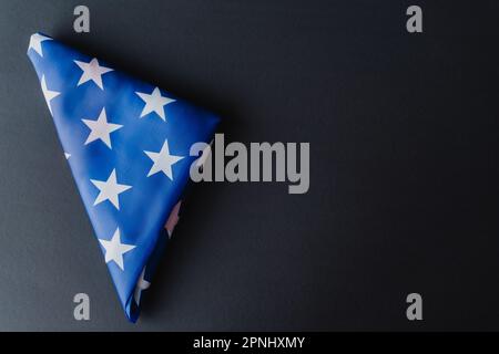 Folded into triangle American flag on memorial marble tomb with R.I.P ...