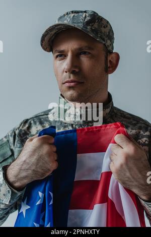 upset American soldier holding flag of United States while crying ...