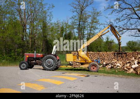 Old agricultural tractor with crane for loading wood log Stock Photo ...