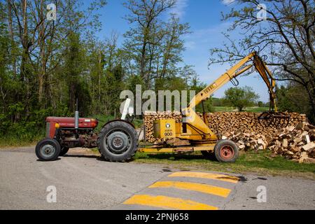 Old agricultural tractor with crane for loading wood log Stock Photo ...