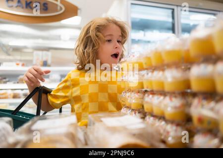Kid choosing cakes, cupcake muffin. Shopping in supermarket. Kids ...