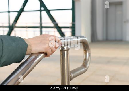 Man holding onto railing on rope bridge Stock Photo - Alamy