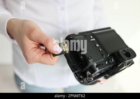 Female operator puts information storage device into camera Stock Photo ...