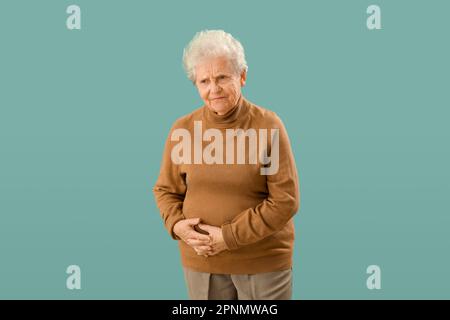 Senior woman with appendicitis on green background Stock Photo - Alamy