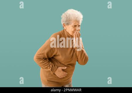 Senior woman with appendicitis on green background Stock Photo - Alamy