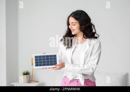Teenage girl with portable solar panel in bedroom Stock Photo - Alamy